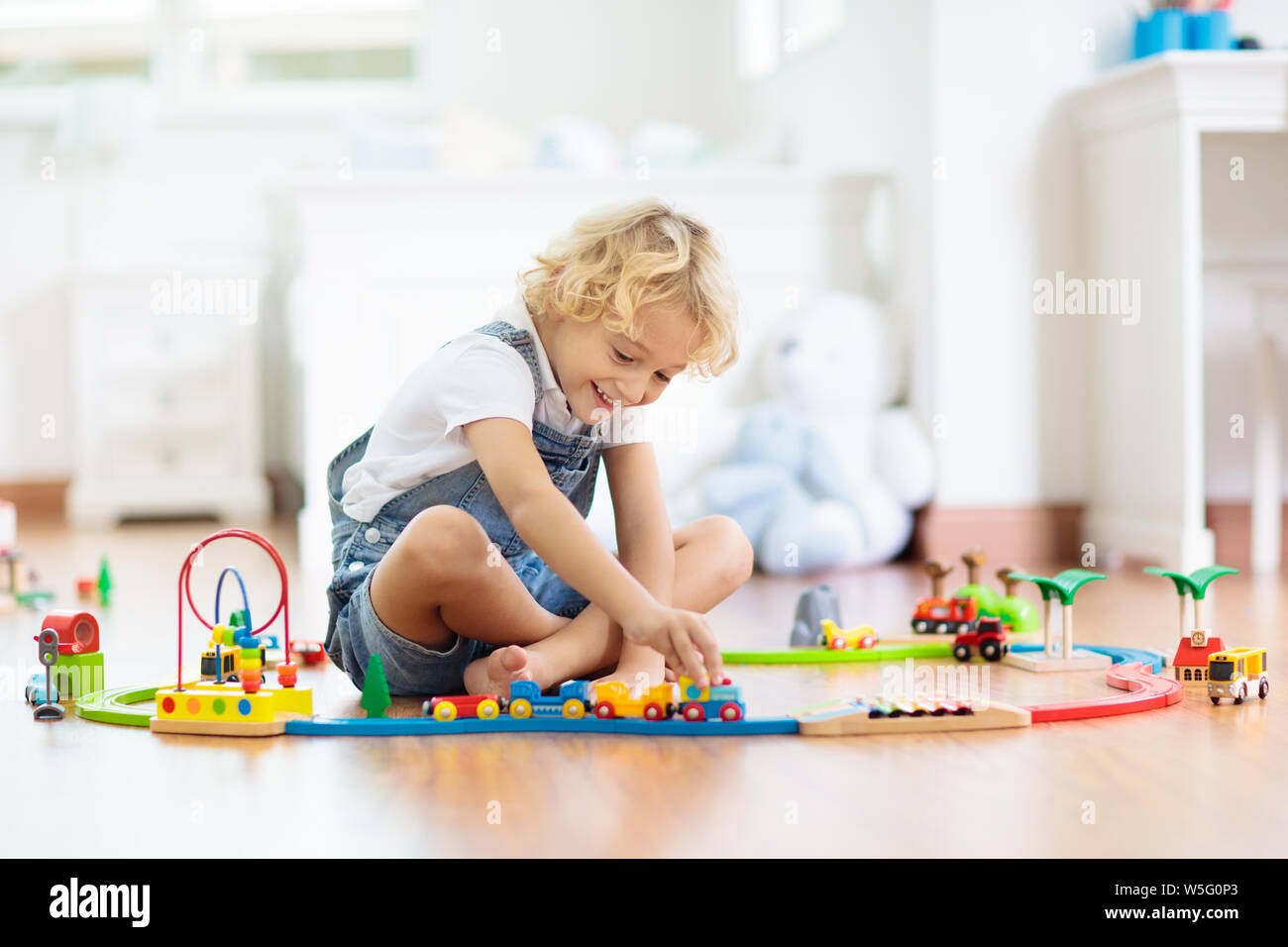 Kids play with wooden railway. Child with toy train. Educational toys ...