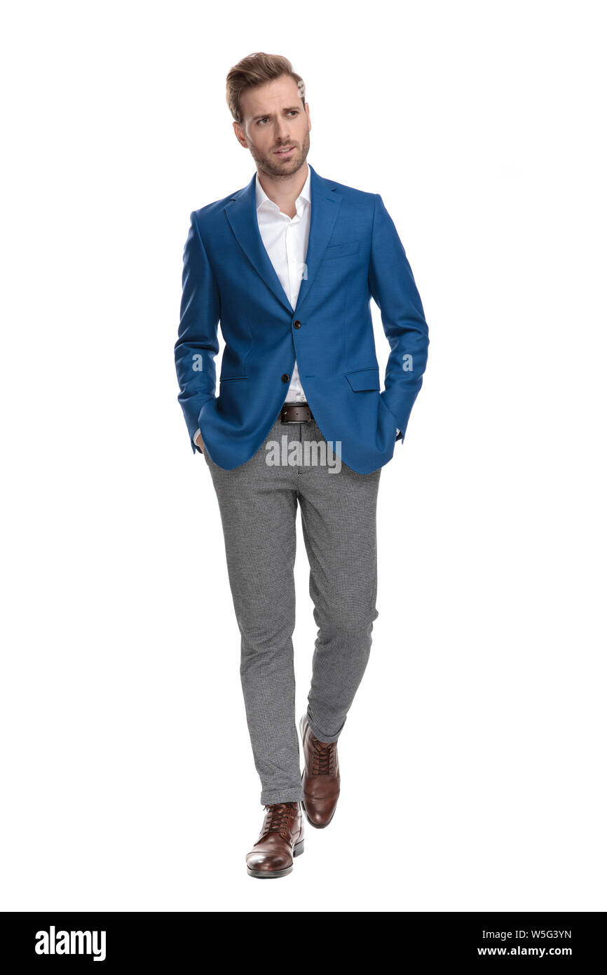 Upset businessman walking forward with both hands in his pockets while ...