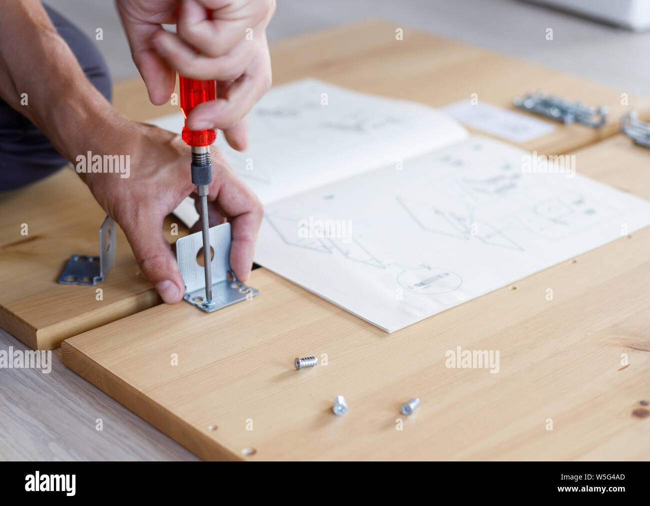 Man assembling furniture at home using screwdriver Stock Photo - Alamy