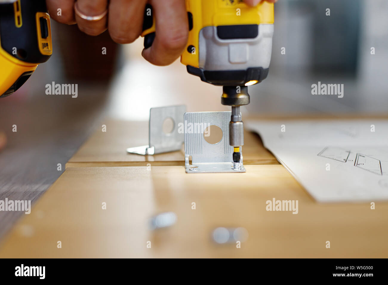 Man assembling furniture at home using a cordless screwdriver Stock ...