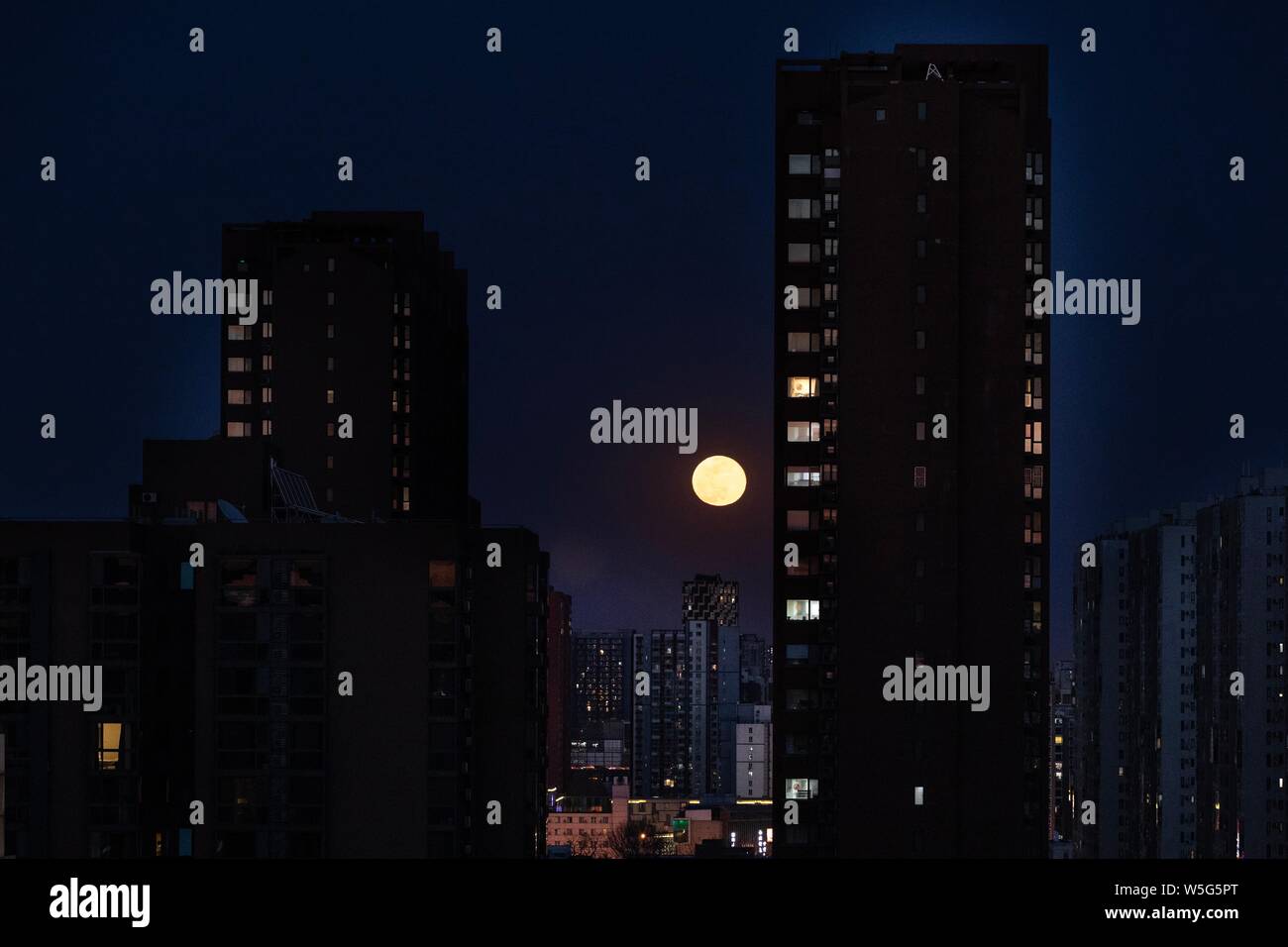 A supermoon is seen in the sky over the high-rising buildings in ...