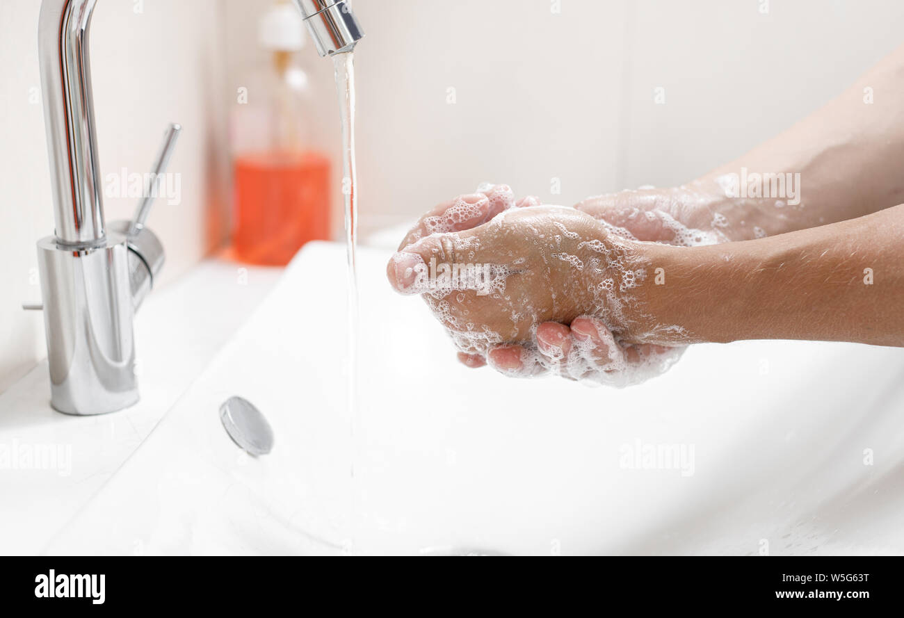 Washing hands with soap. Man cleaning hands in a bathroom Stock Photo ...