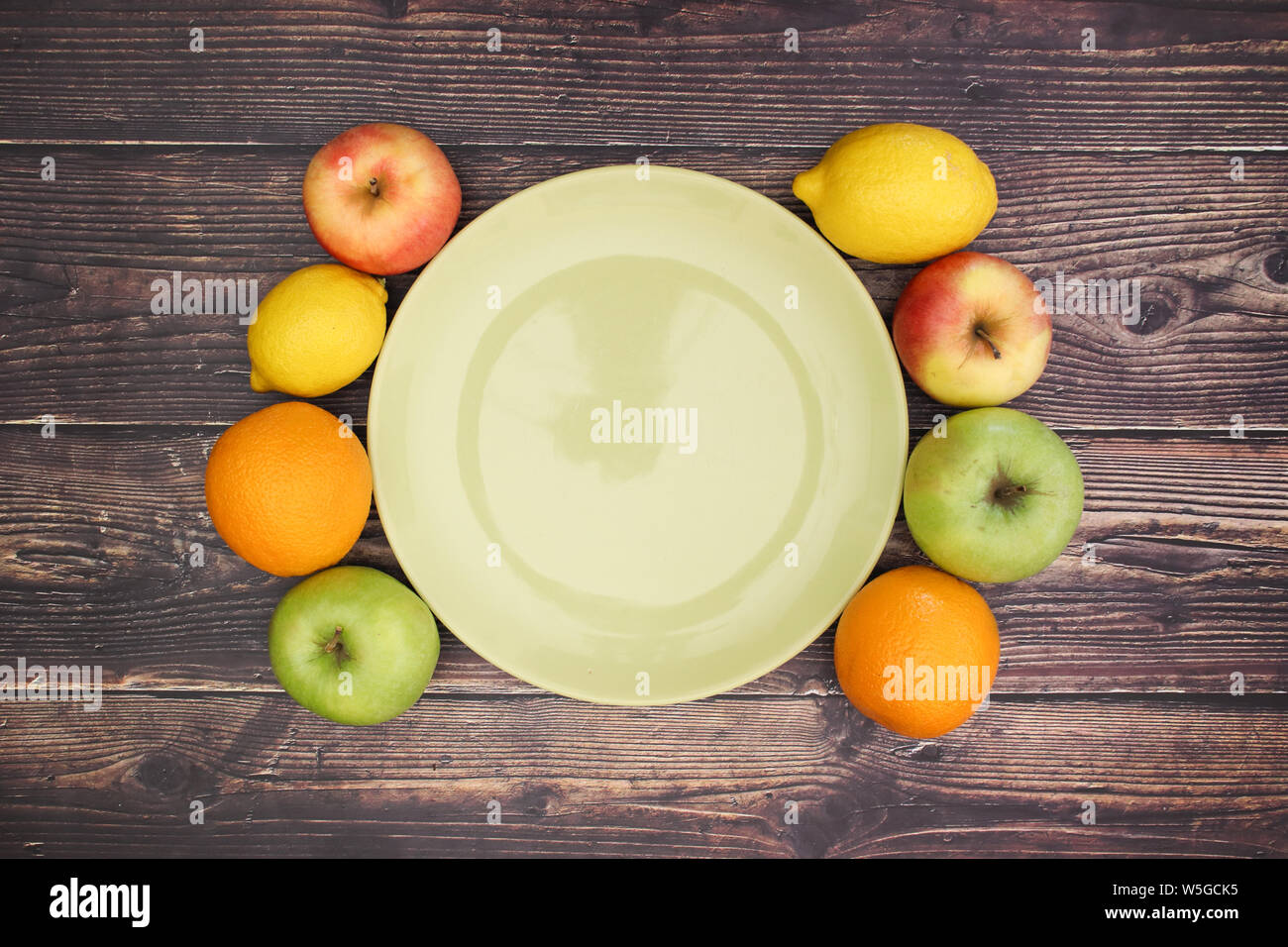 Fruits around the green plate Stock Photo - Alamy
