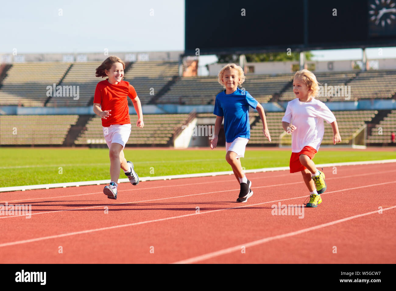 Child running in stadium. Kids run on outdoor track. Healthy sport ...