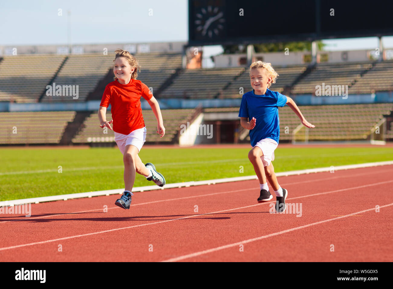 Child running in stadium. Kids run on outdoor track. Healthy sport ...