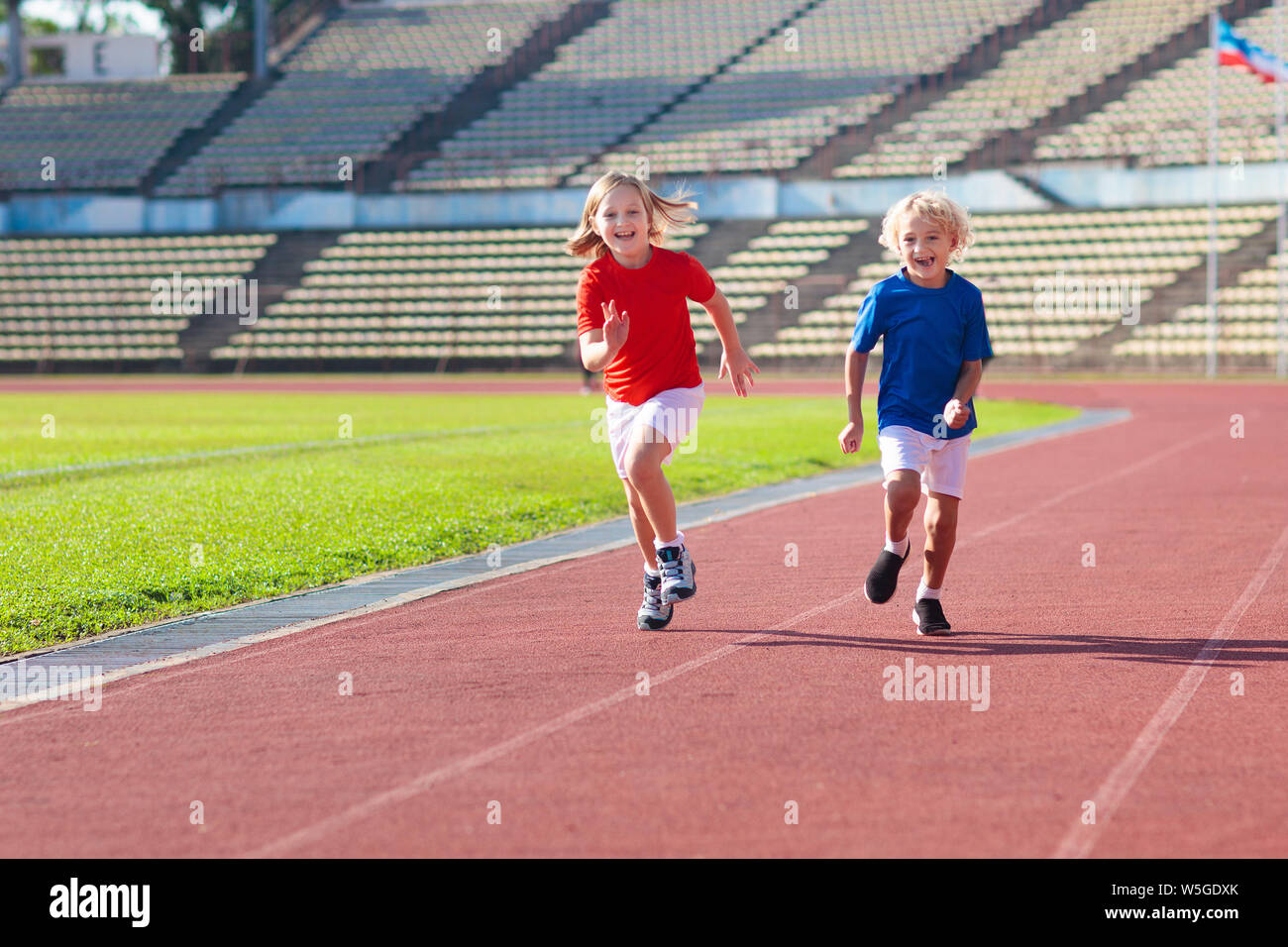 Child running in stadium. Kids run on outdoor track. Healthy sport ...