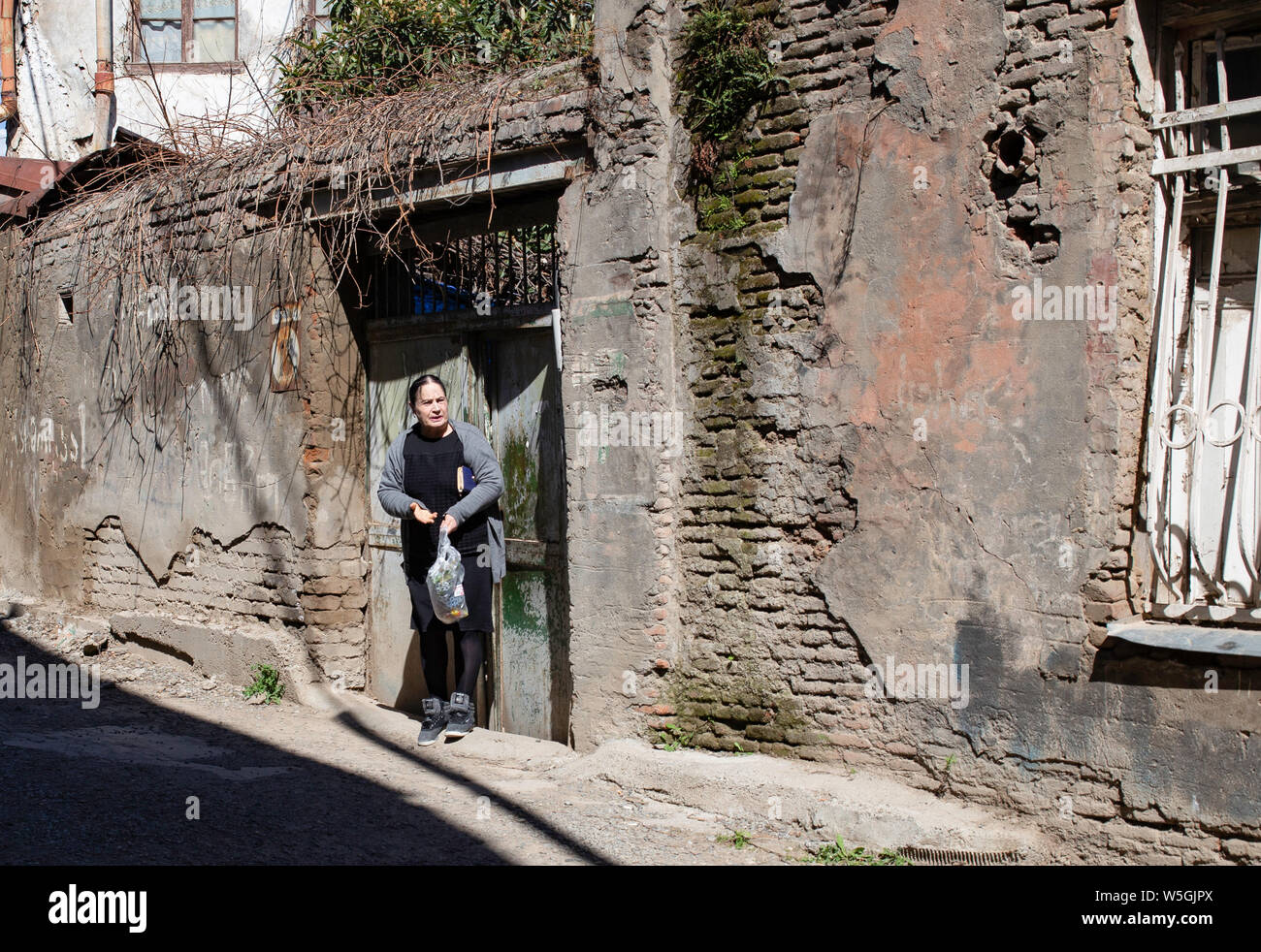 Tbilisi / Georgia - Old woman walking on the street in a poverty ...