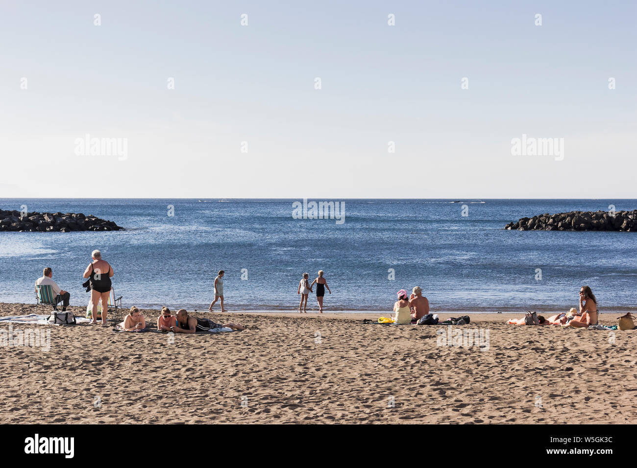 Tourists using mobile phones on a Tenerife beach, Costa Adeje Stock ...