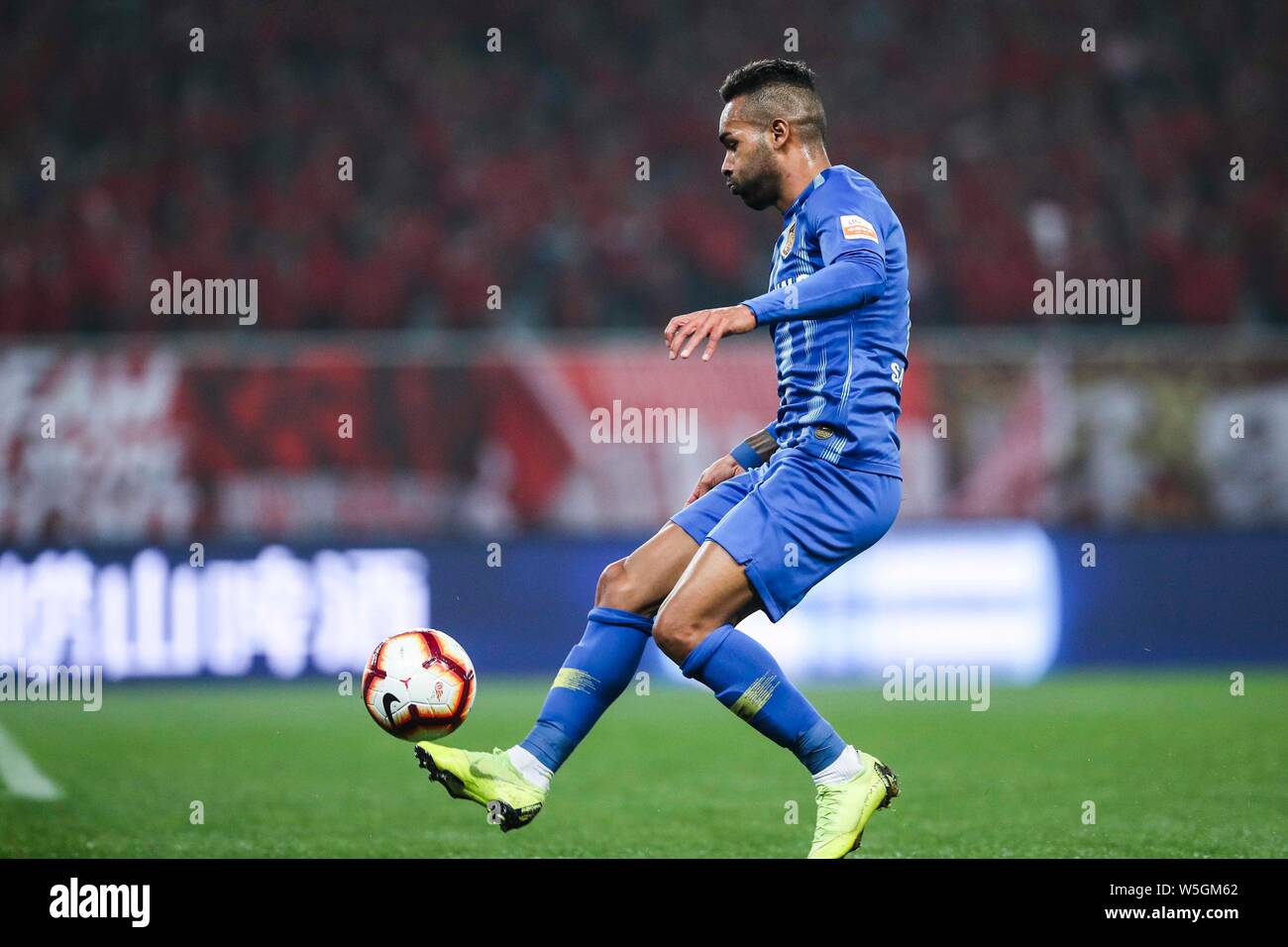 Brazilian football player Alex Teixeira of Jiangsu Suning F.C. dribbles ...