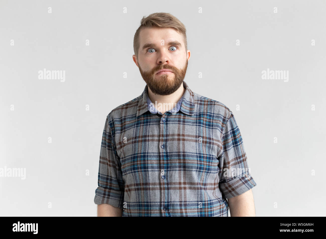 Young man with a mustache and beard making bulging eyes in surprise ...