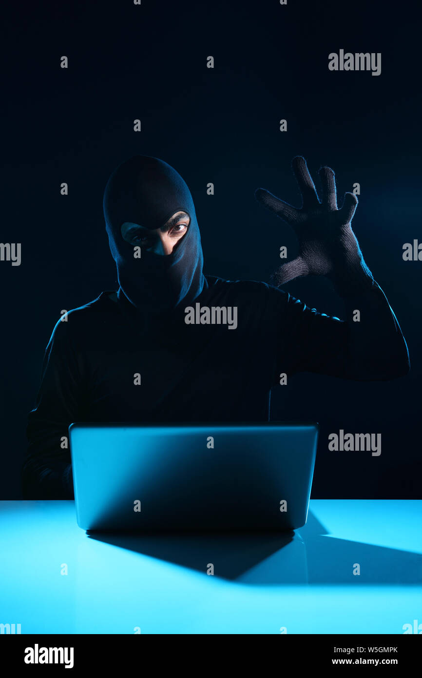 Hacker stealing information from laptop Stock Photo - Alamy