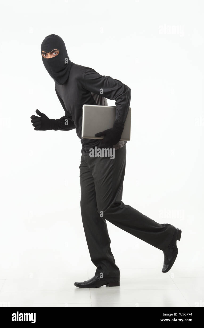 Hacker running with a laptop Stock Photo - Alamy