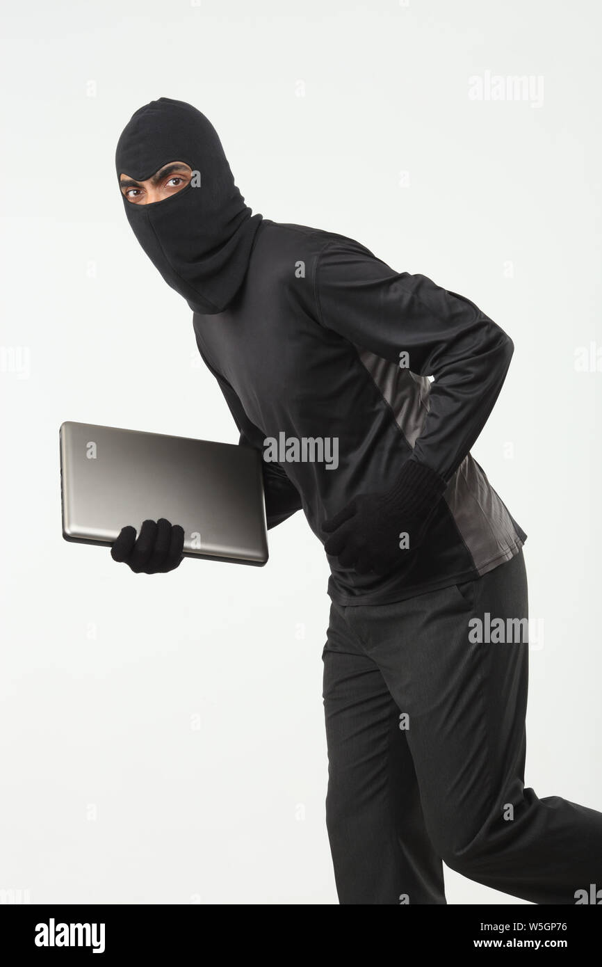 Hacker running with a laptop Stock Photo - Alamy