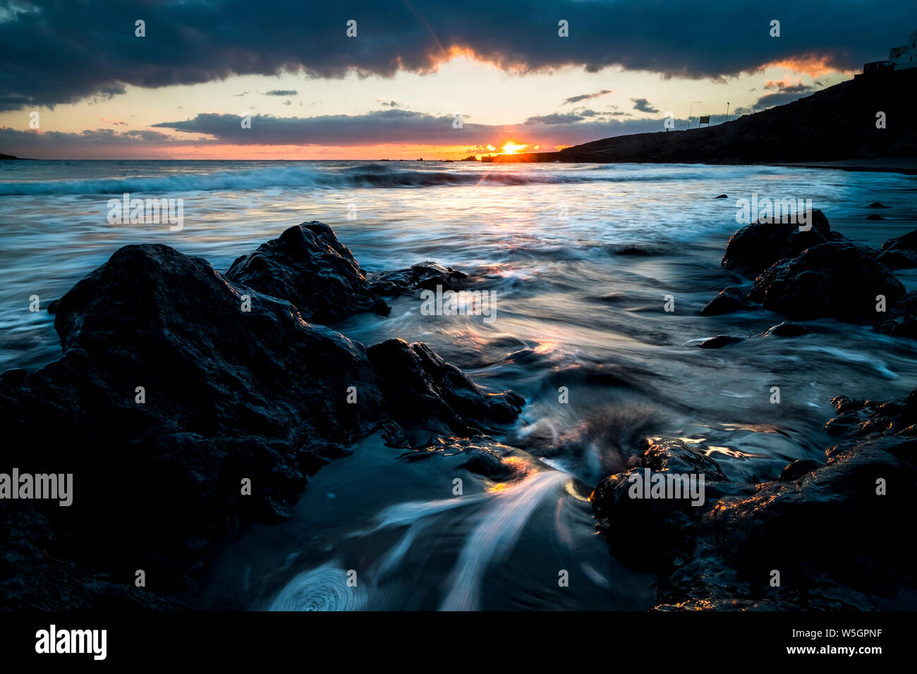 Cold coloured dramatic beautiful sunrise at the beach with ocean ...