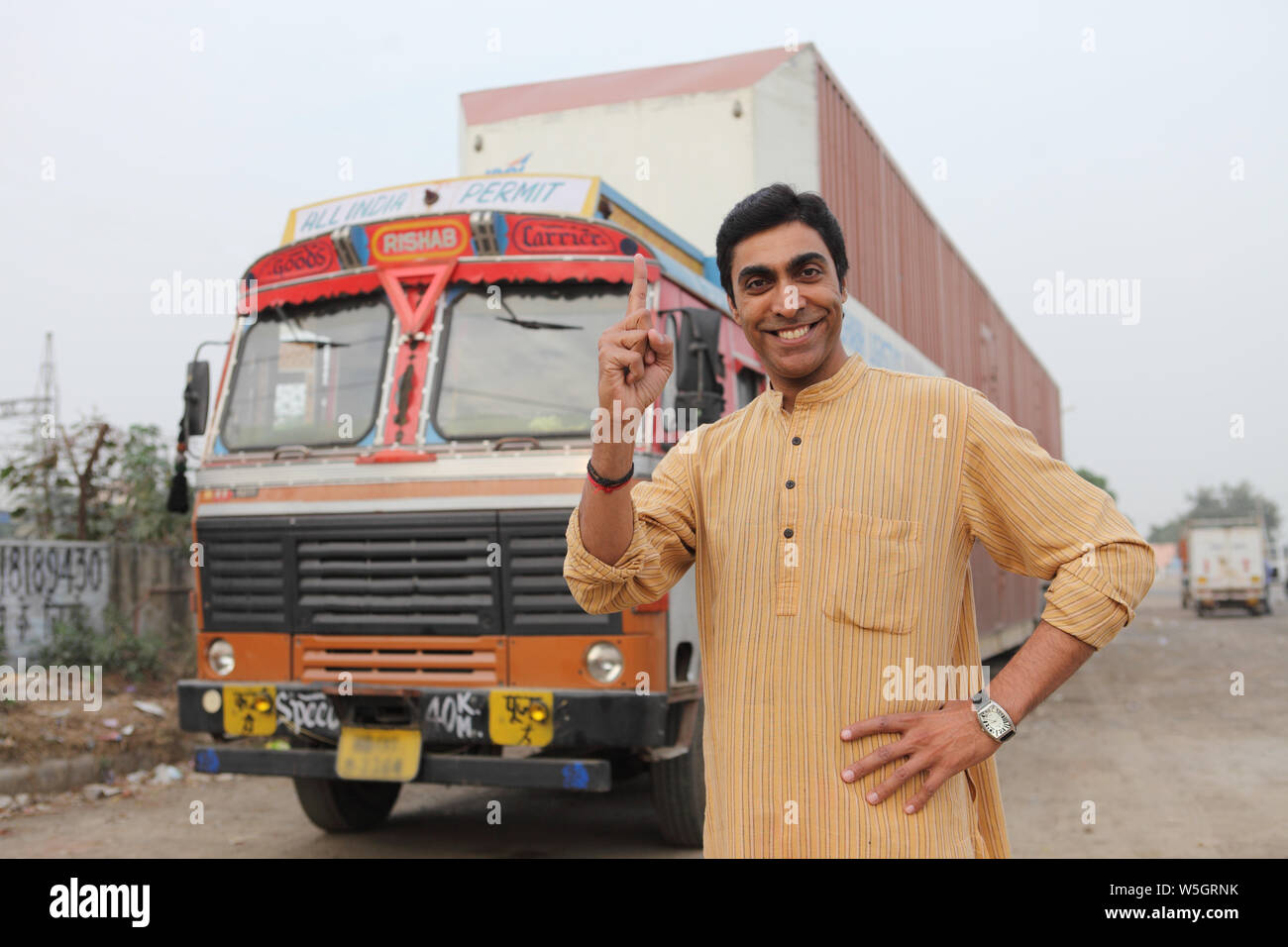 Truck driver smiling with pointing upward Stock Photo - Alamy