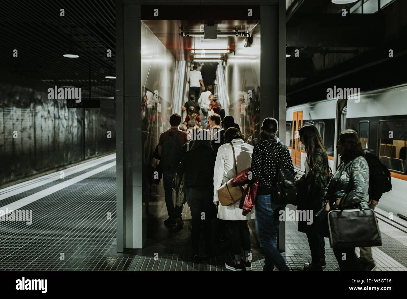 Grayscale shot of people standing in a line at a subway station Stock ...