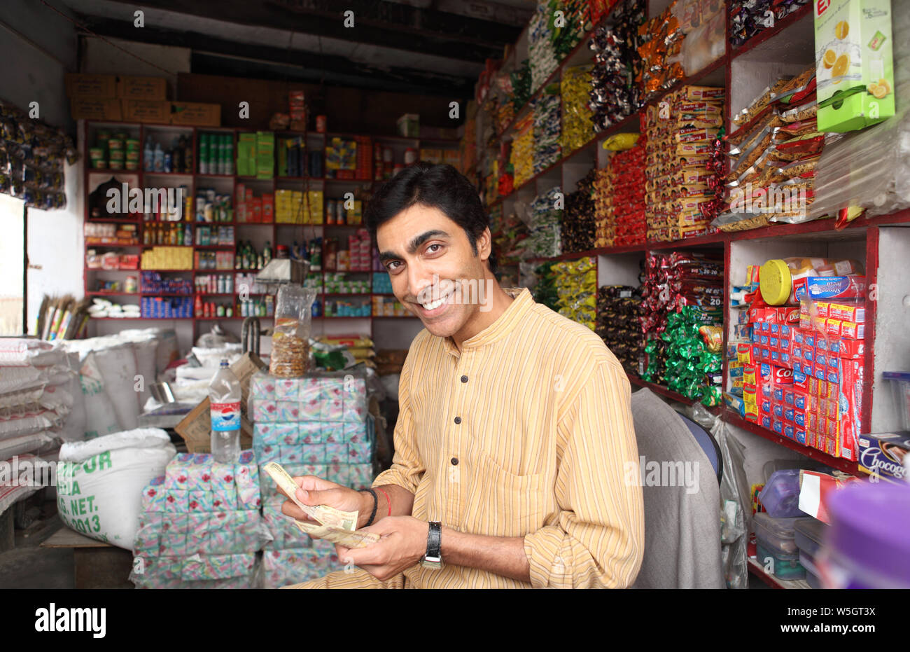 Shopkeeper counting money in grocery shop Stock Photo - Alamy