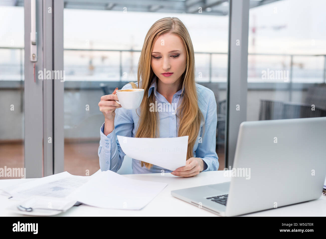 Busy business woman doing paper work and drinking coffee Stock Photo ...
