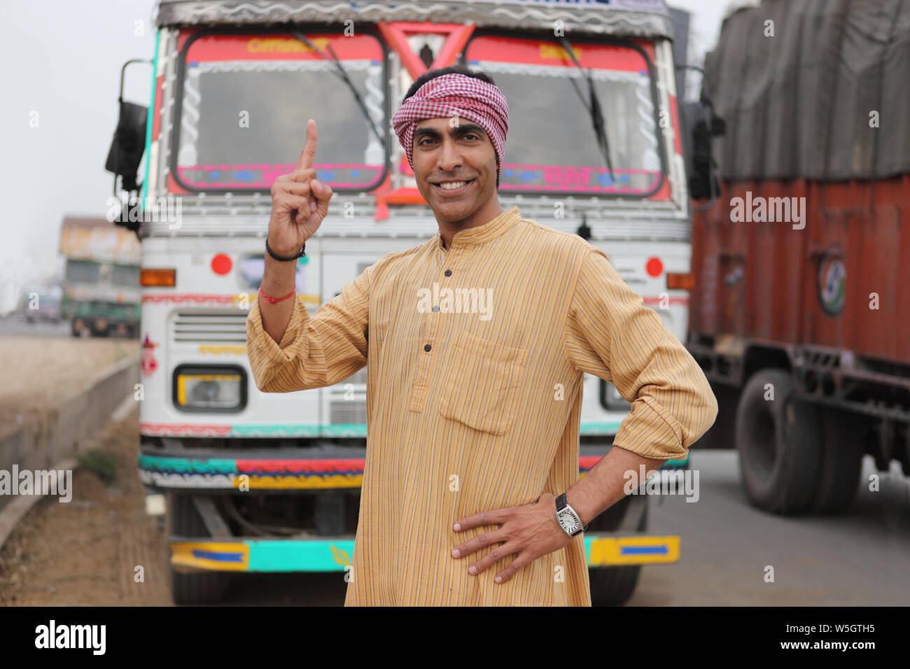 Truck driver smiling with pointing upward Stock Photo - Alamy