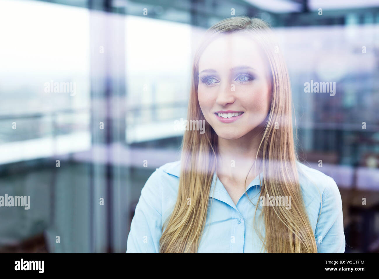 Smiling female manager standing in an office and looking through a ...
