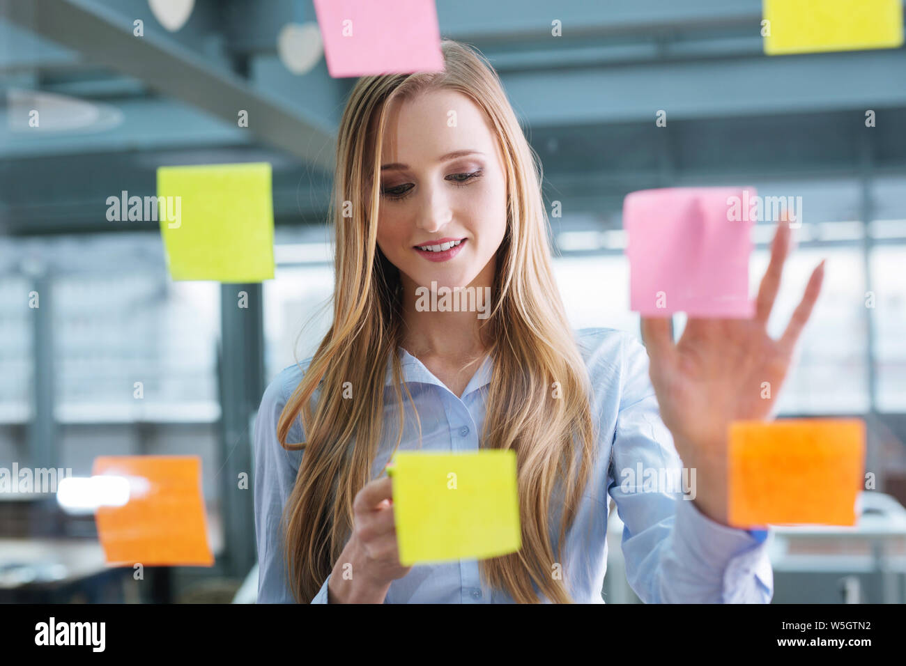 Young female manager analyzing ideas written on sticky notes Stock ...