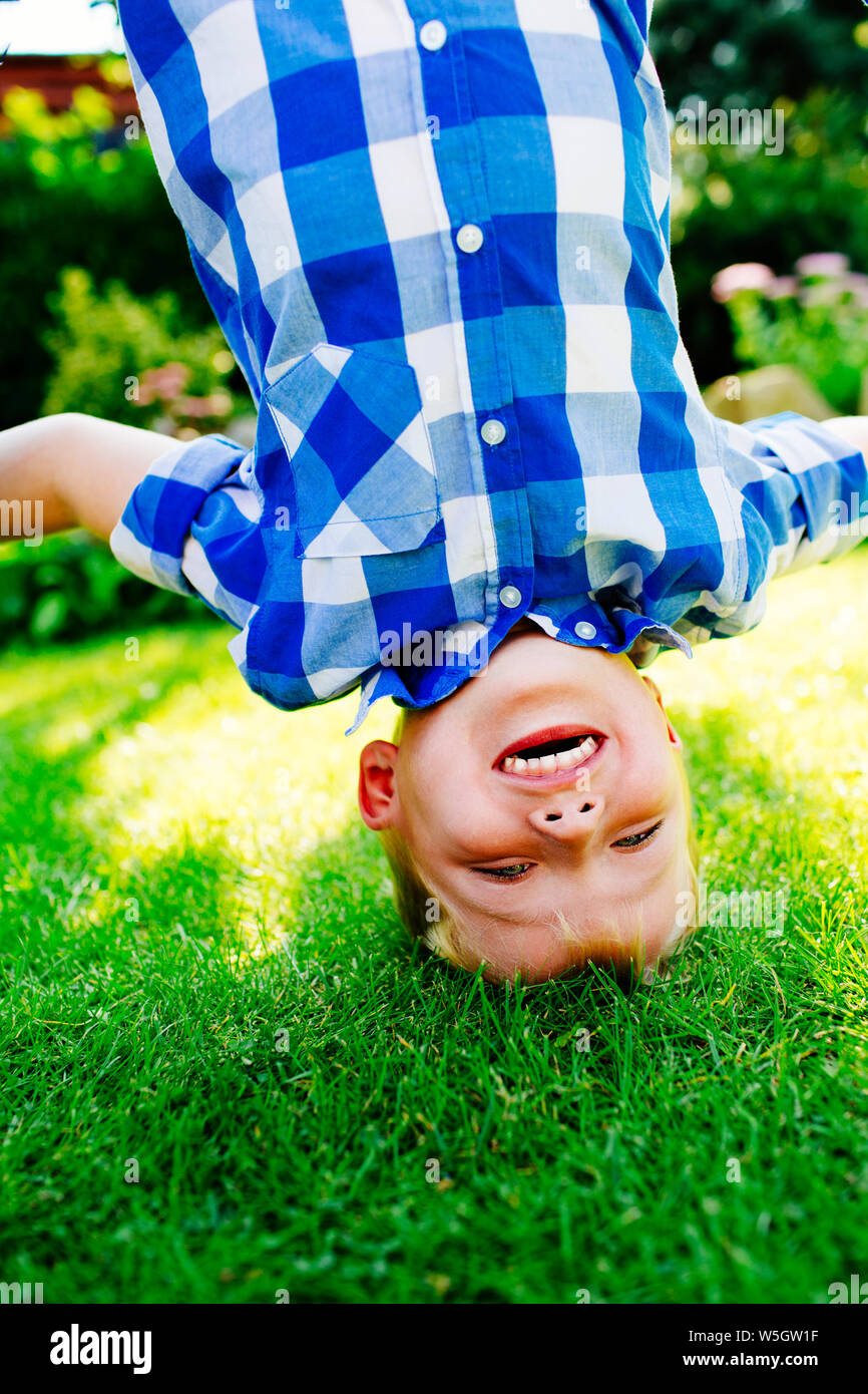 Young happy boy standing on head outdoors Stock Photo - Alamy