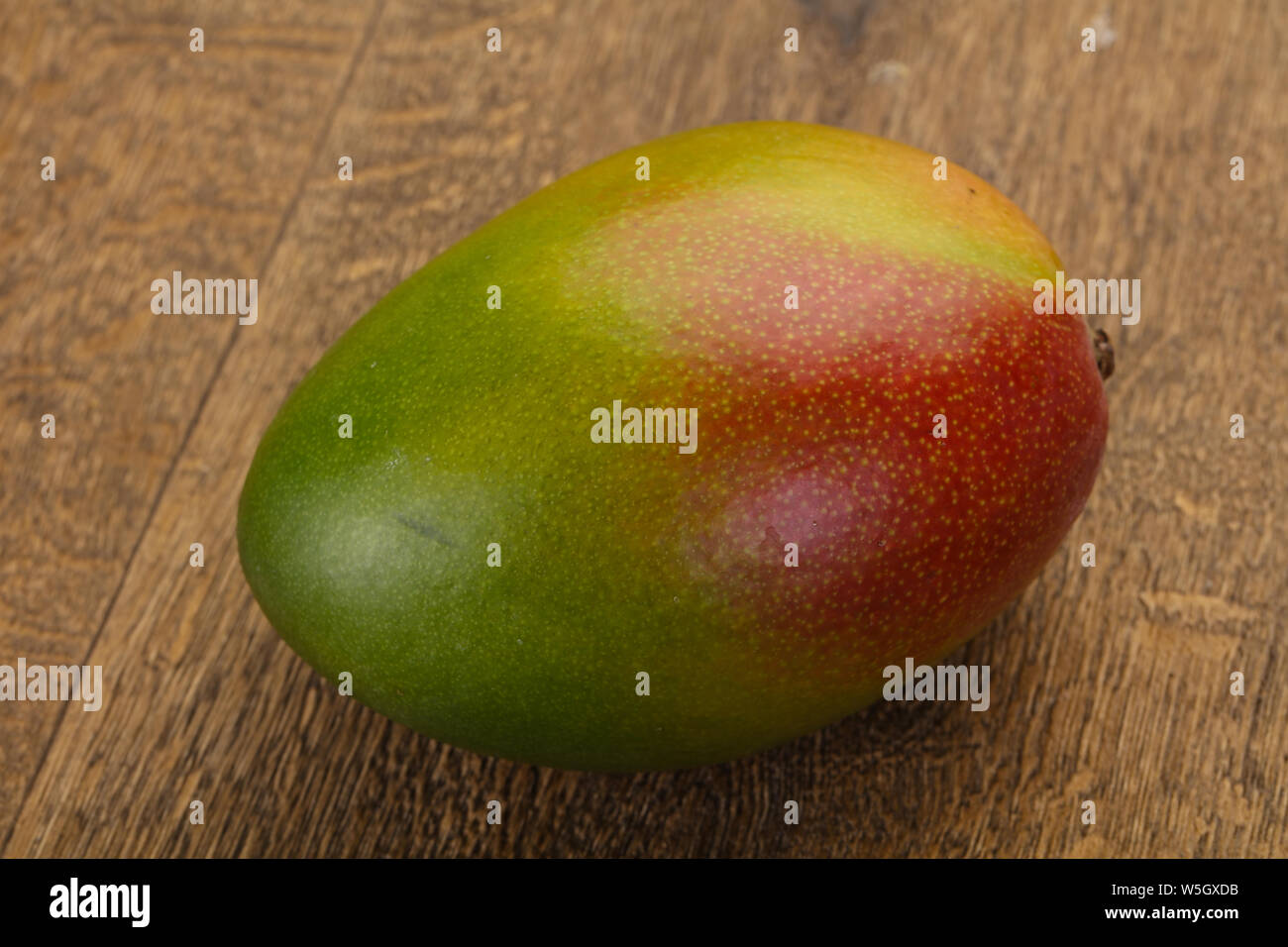 Sweet tasty mango over wooden background Stock Photo - Alamy