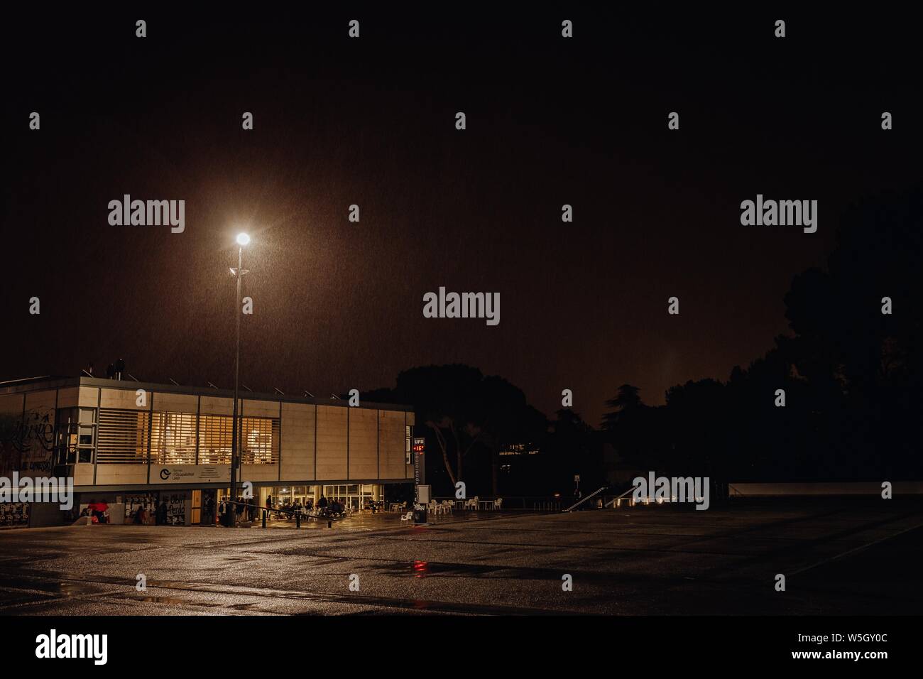 Shot of a building on a wet street during dark rainy night Stock Photo ...