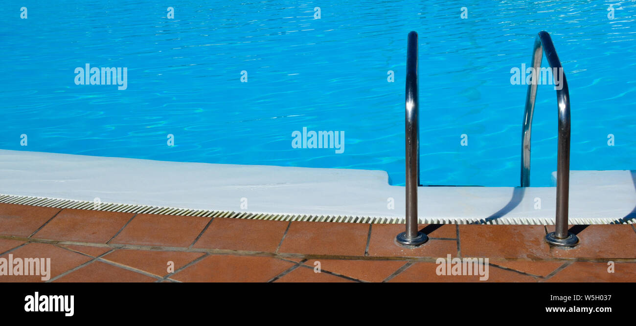 Swimming pool with grab bars ladder background. Summer concept.Panorama ...