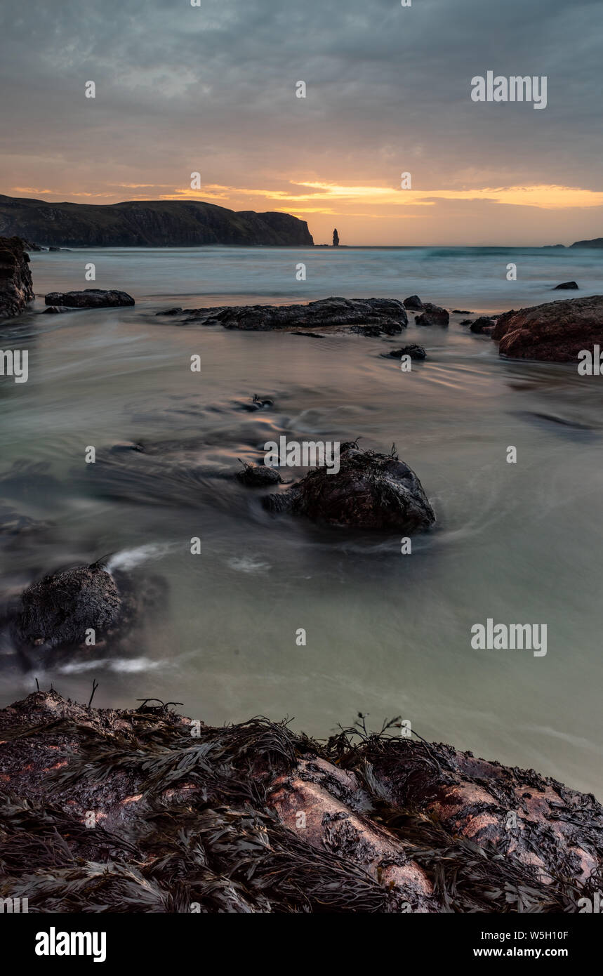 Rock formations at Sandwood Bay, with Am Buachaille sea stack in far ...