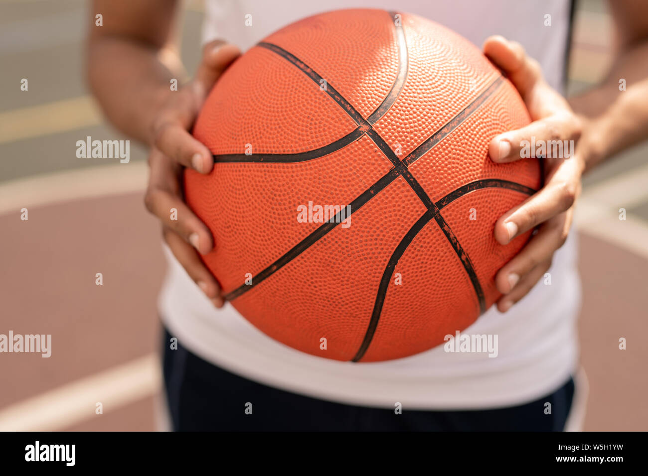 Ball for playing basketball in hands of young active player Stock Photo ...