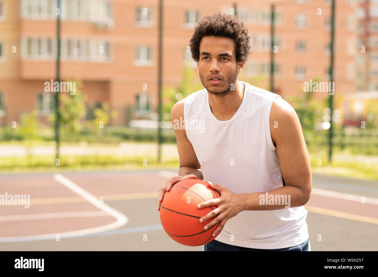 Young basketball player with ball looking at basket during game Stock ...
