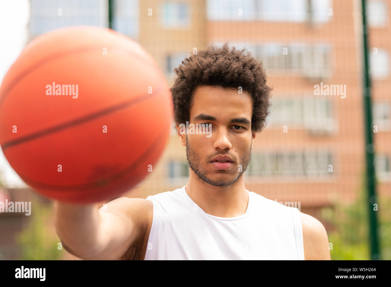 Young serious basketball player looking at you while passing ball Stock ...