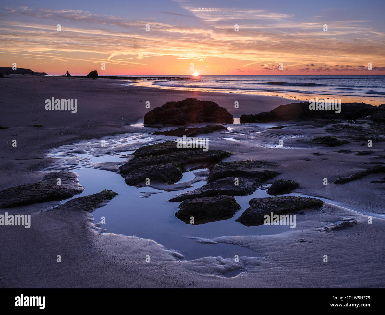 Sunrise on the shoreline with rocks and rock pools at Orcombe Point ...