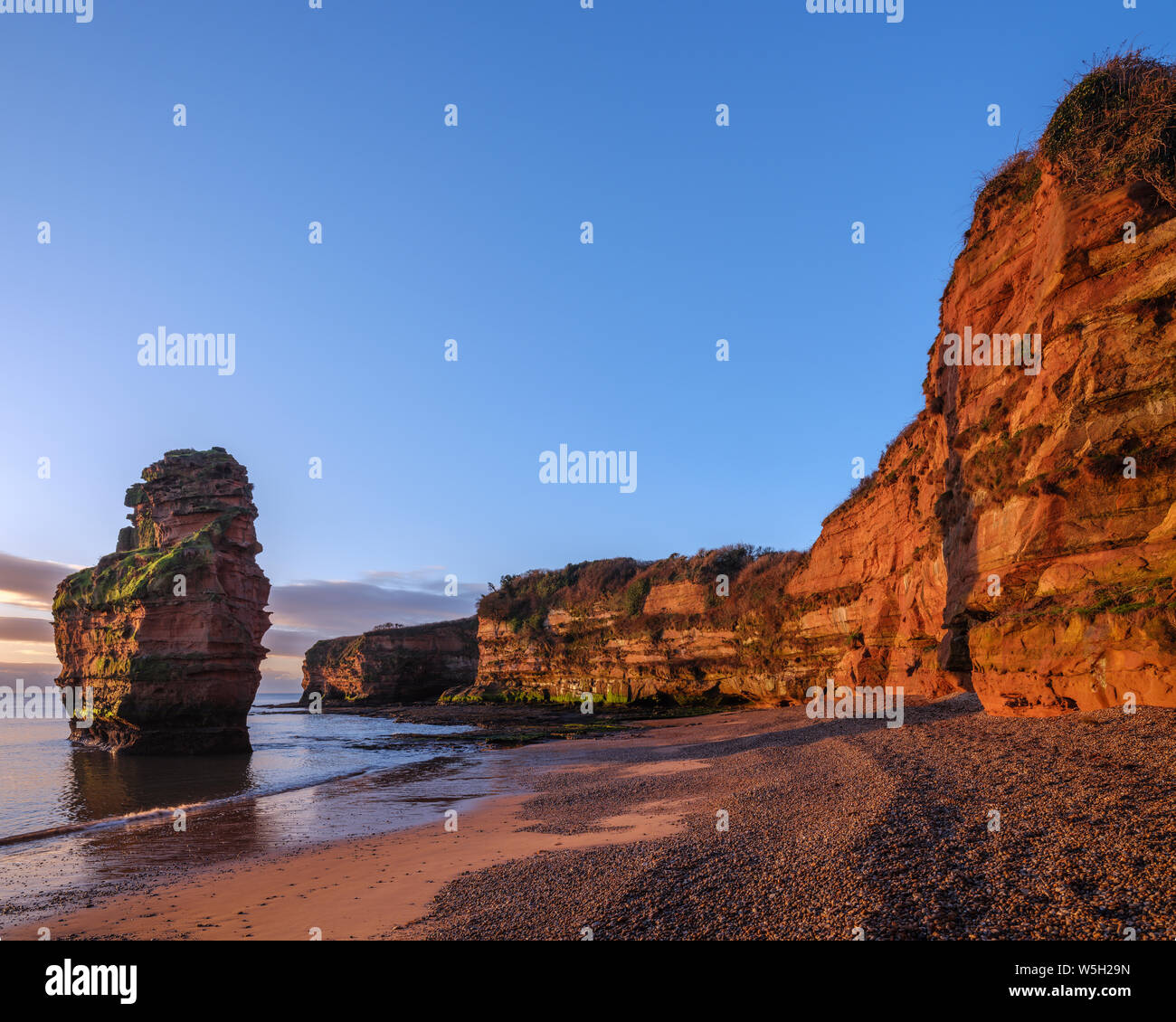 Dawn on the beach with one of the majestic sea stacks at Ladram Bay ...