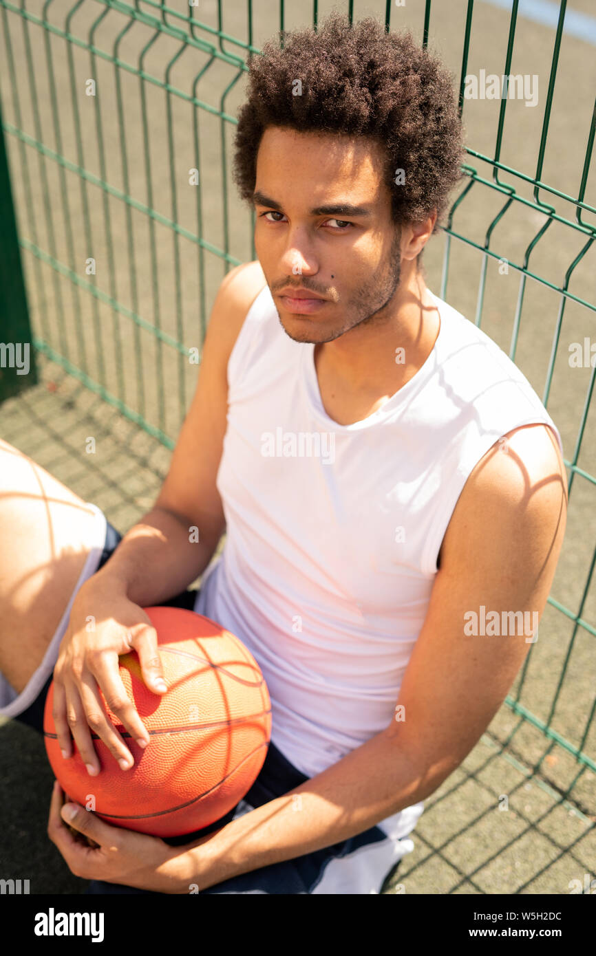 Handsome active guy with ball looking at you while having rest Stock ...