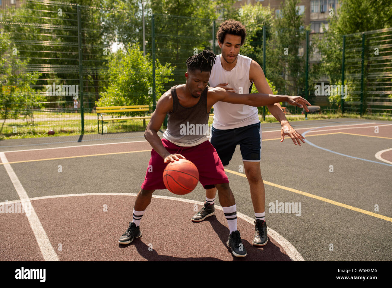 Young professional basketball player defending the ball from attack of ...
