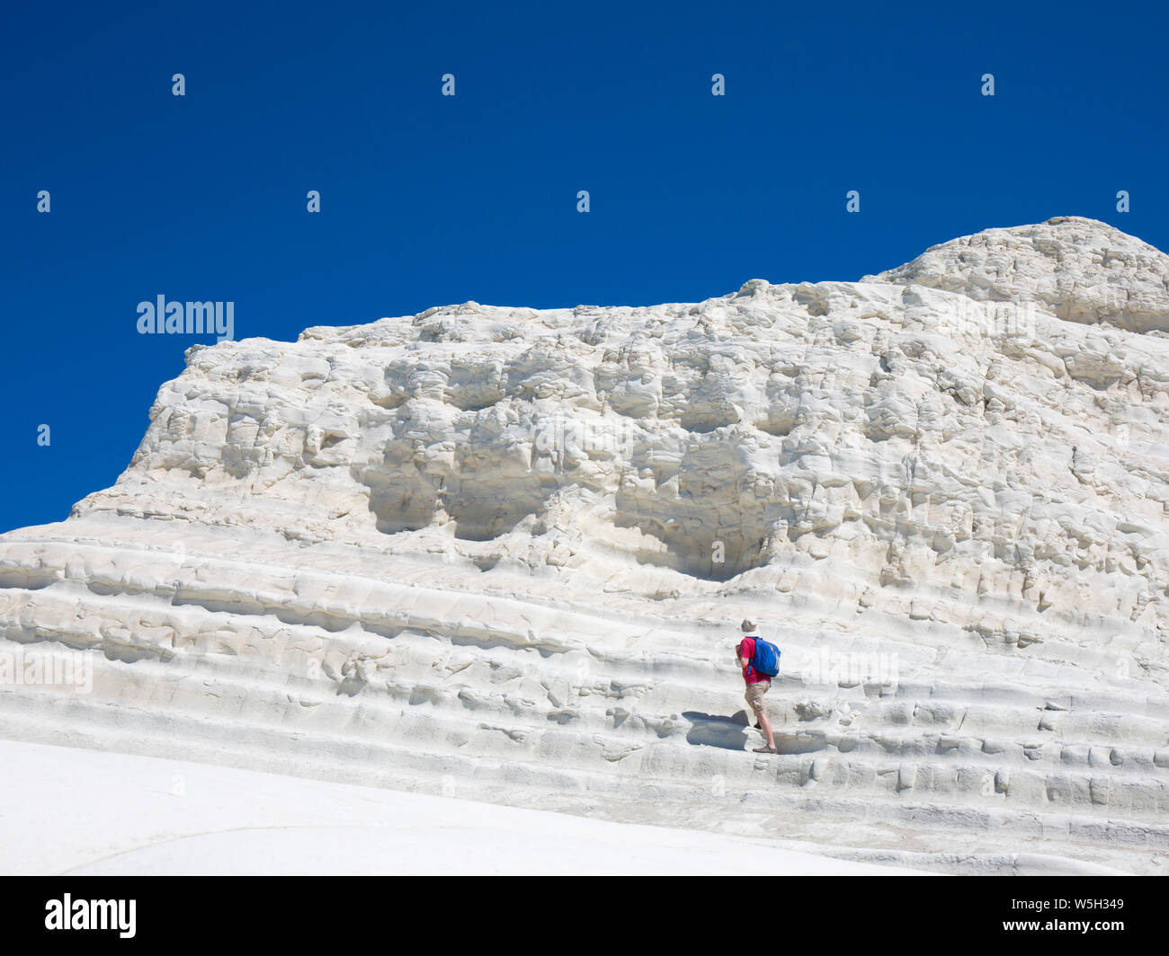 Visitor ascending the white limestone cliffs of the Scala dei Turchi ...
