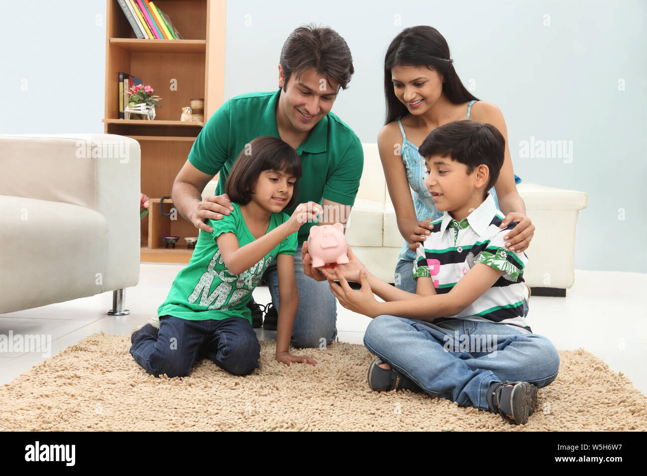 Parents assisting their children to save money Stock Photo - Alamy
