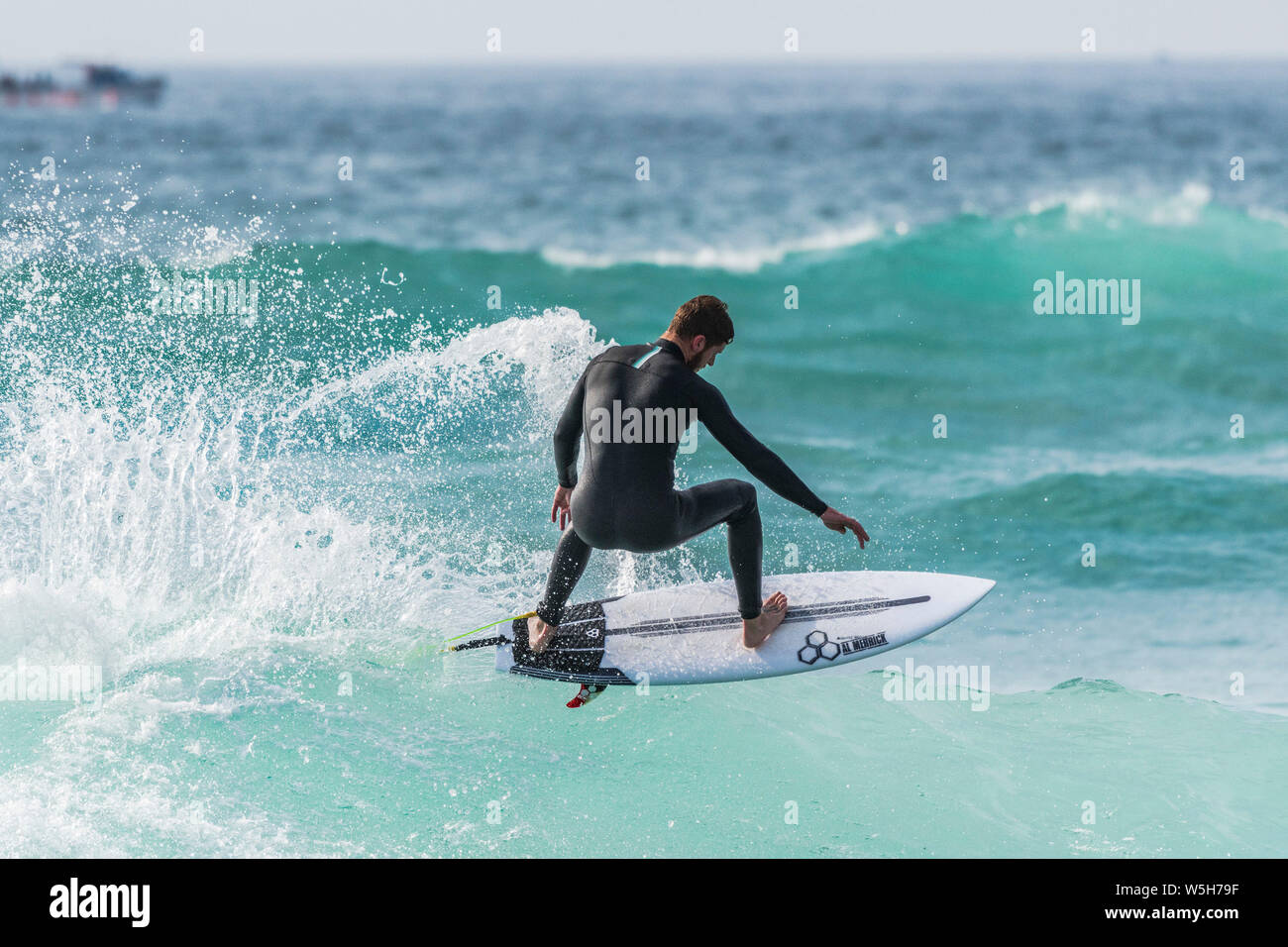 Spectacular action as a male surfer performs an aerial trick at Fistral ...