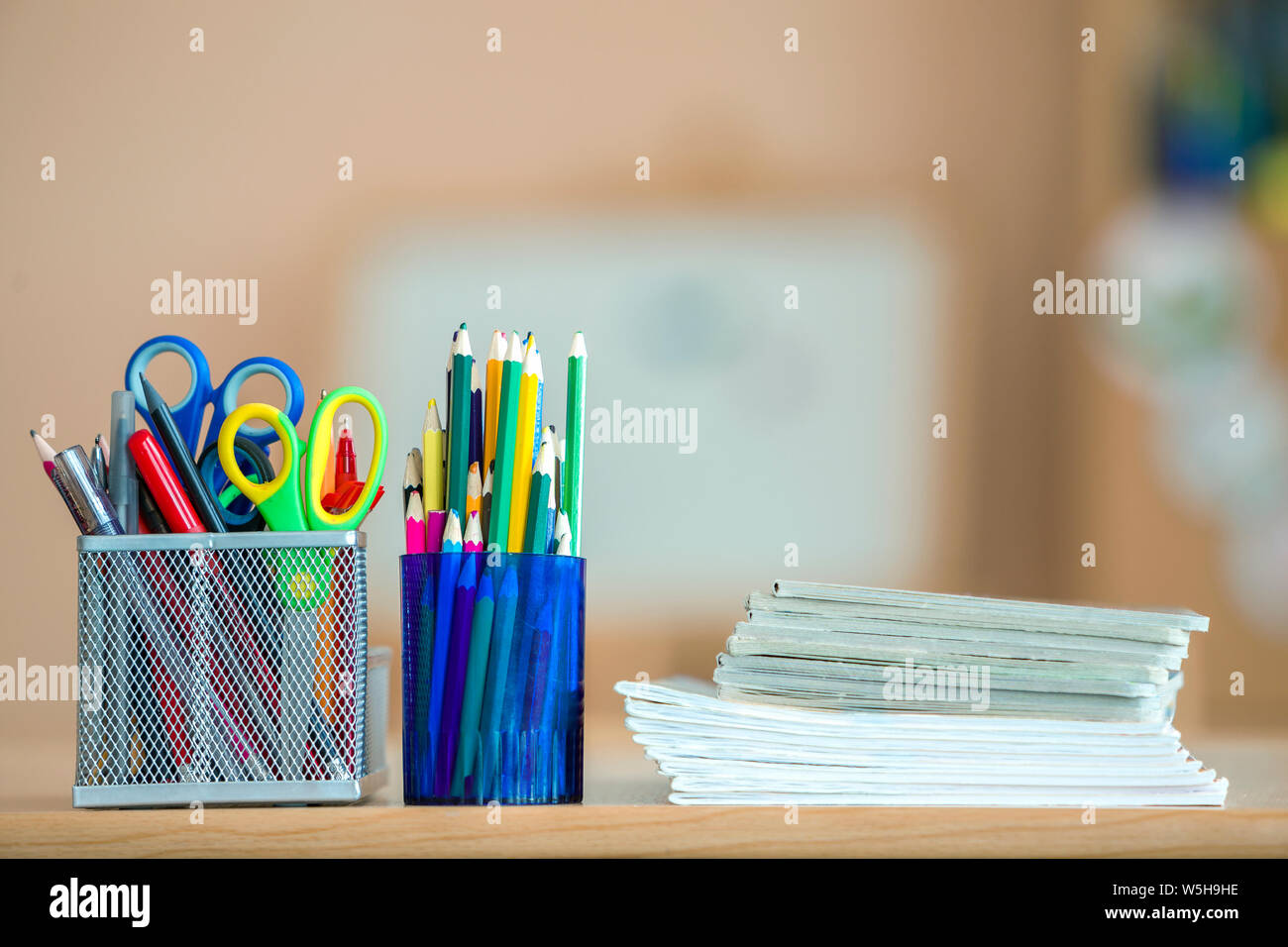 Stack of notebooks, colorful drawing pencils and stationery arrangement ...