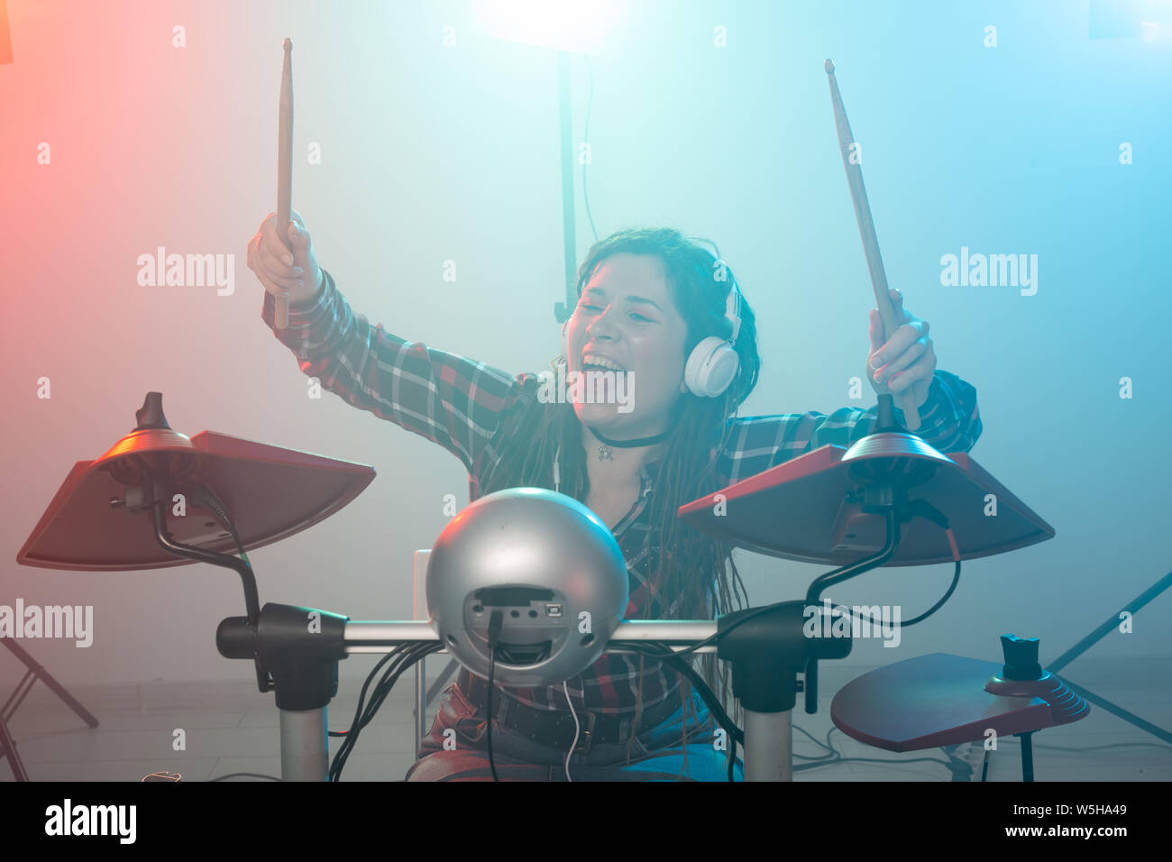 Music, electronic drum set and hobby concept - woman drummer in a ...