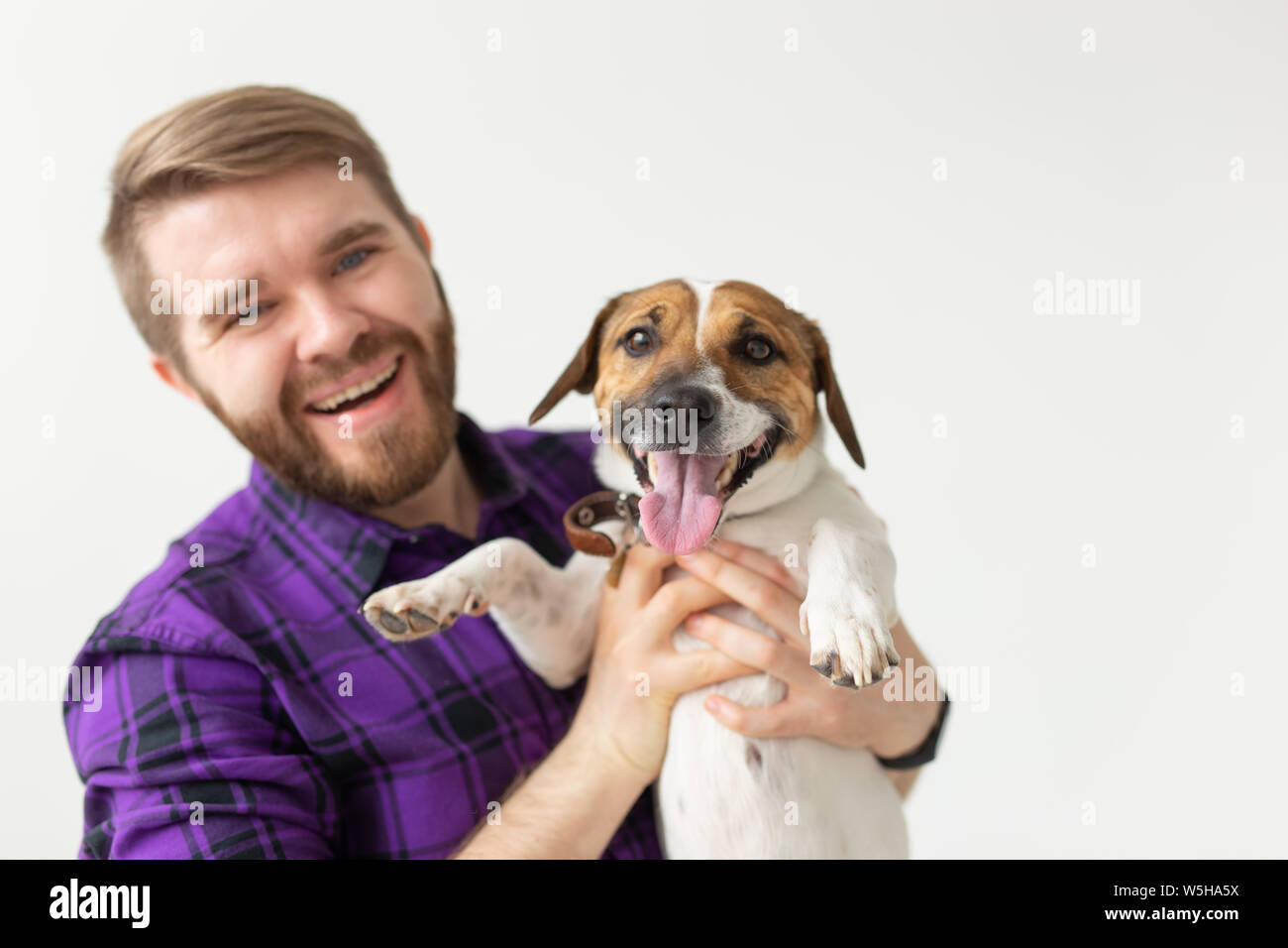 Pet's owner concept - Happy man holding a dog Jack Russell Terrier over ...