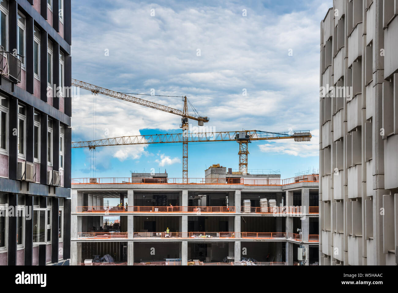 Crane Machines on top of construction building and workers inside with ...