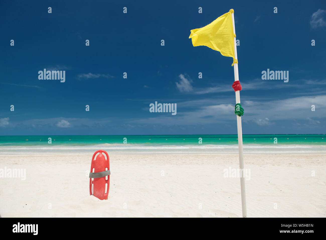 lifeguard rescue can on the beach near yellow wind warning flag ...