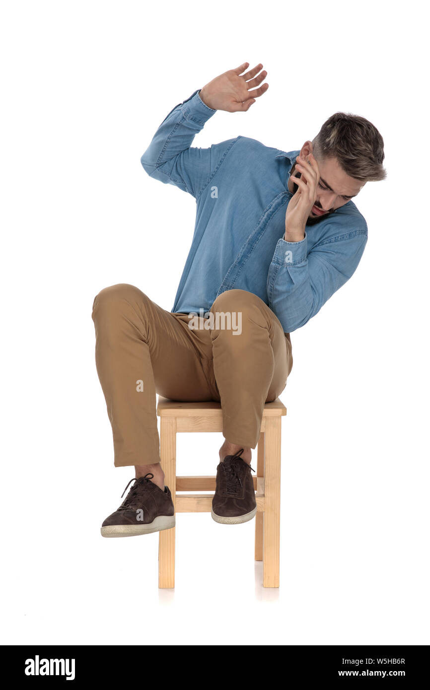 seated scared man in blue jeans shirt defending with his hands on white ...