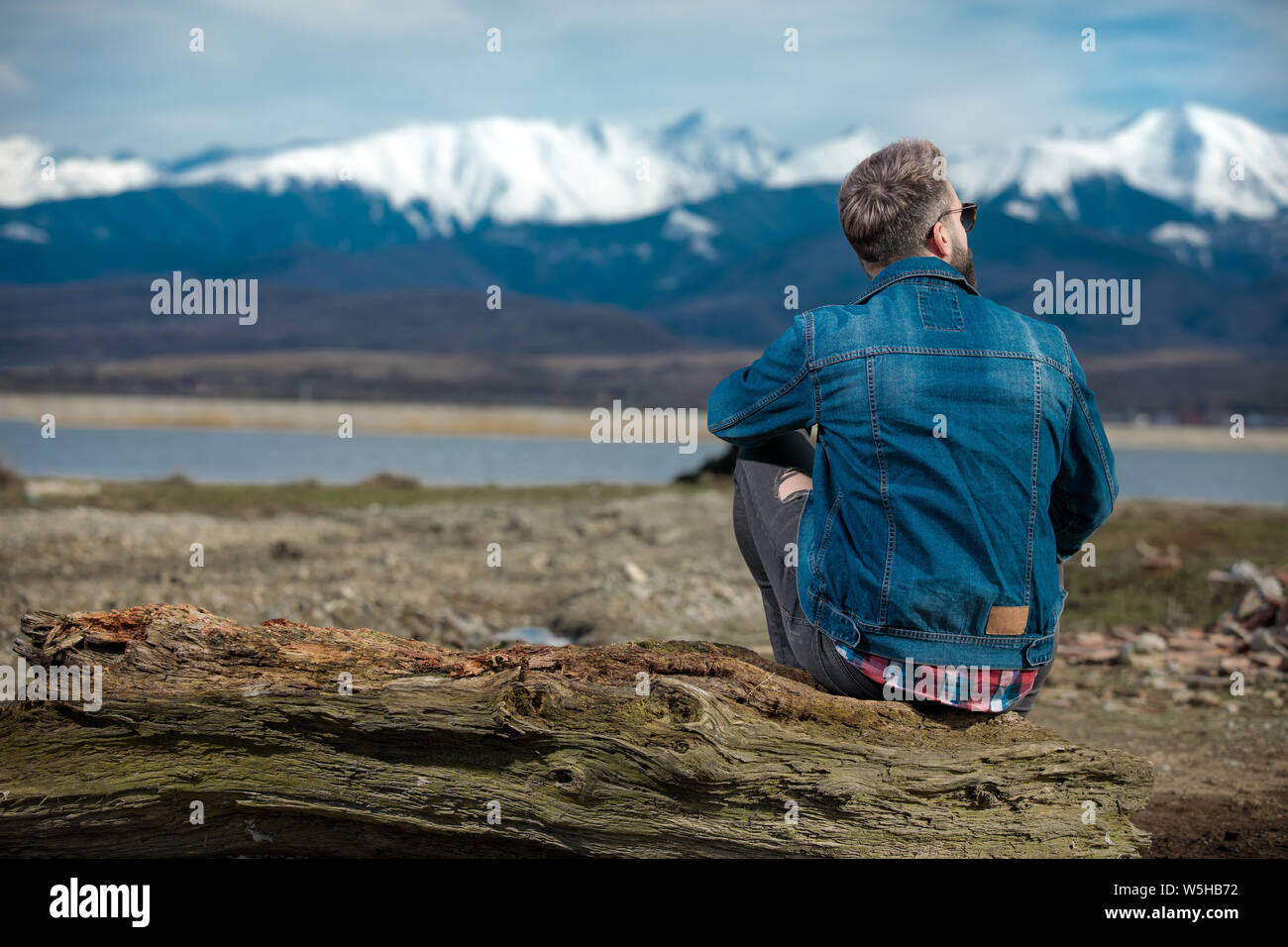 back view of a seated casual man enjoying his view outdoor, looking at ...