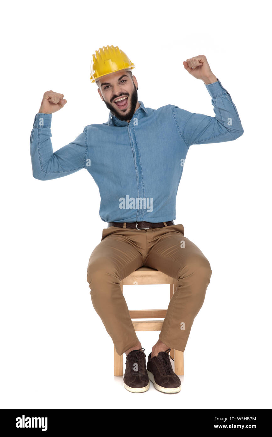 construction engineer with yellow safety helmet sitting with hands up ...