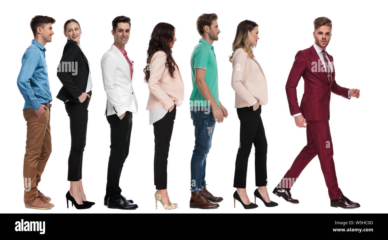 cool elegant man in burgundy suit is walking out of a line of people ...