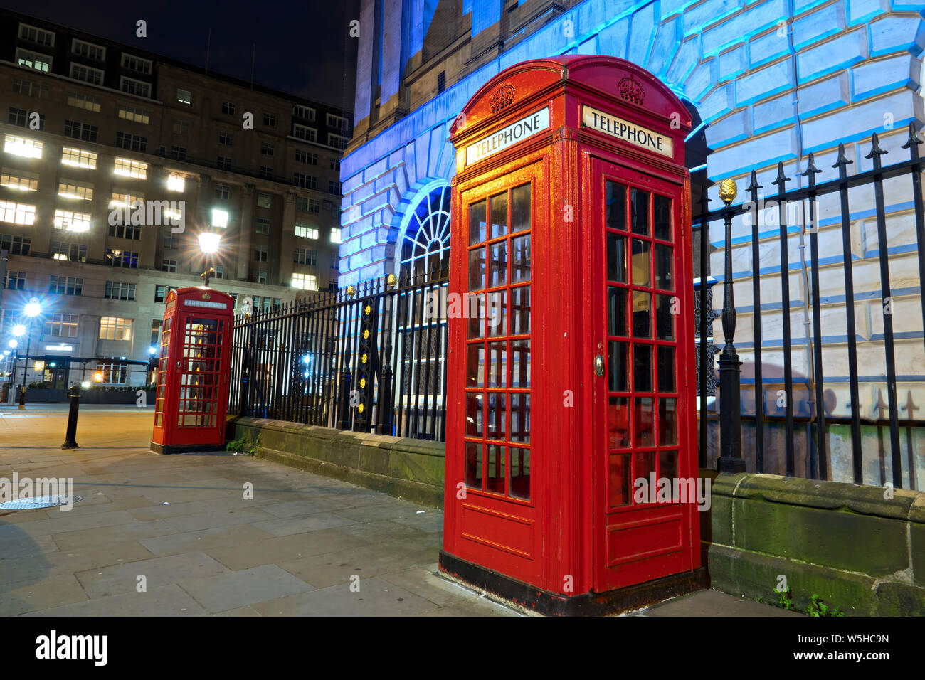 Classic Red British telephone boxes at the side of an illuminated ...